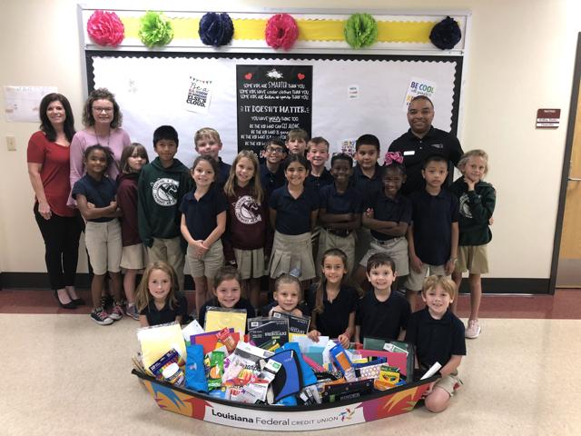 Central Primary School classroom unloads pirogue of donated supplies ...