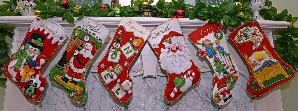 Woman sews colorful stockings for family members as a Christmas ...