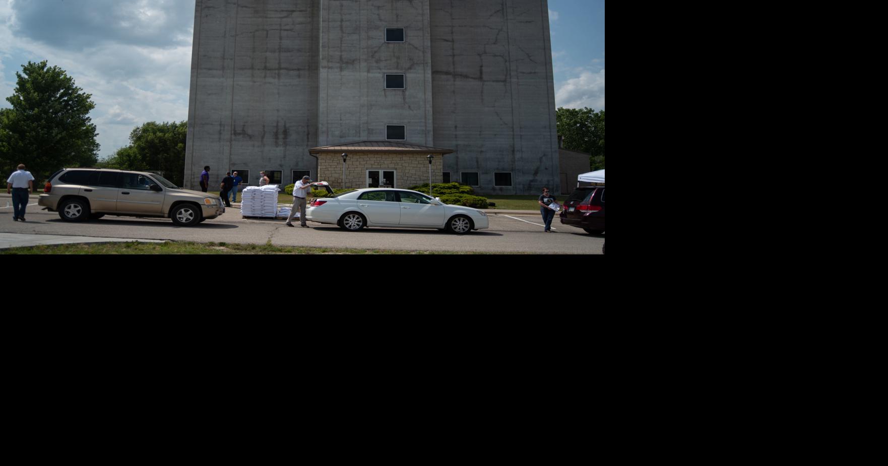 Paul Blodgett, middle, puts a 10-bag of flour in someoneÕs trunk ...