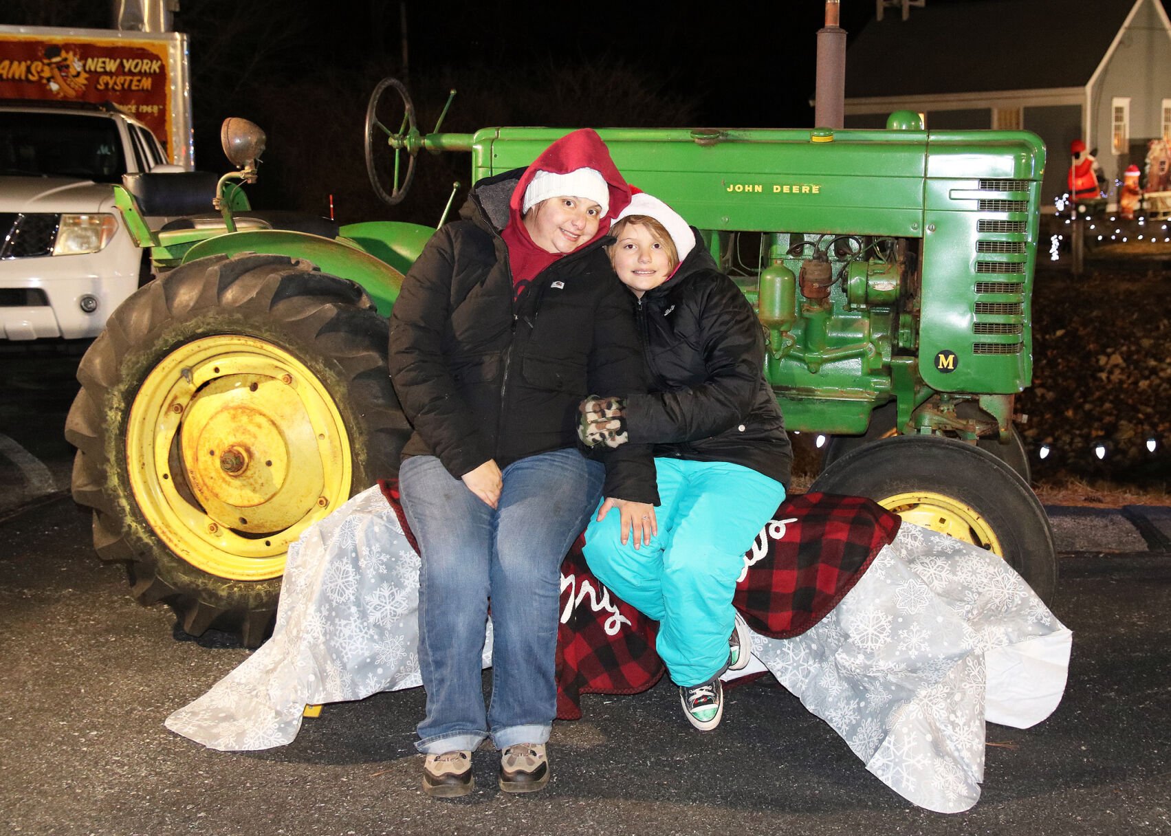 Kendall and Emily Stone pose for a photo sitting on a bale of hay ...