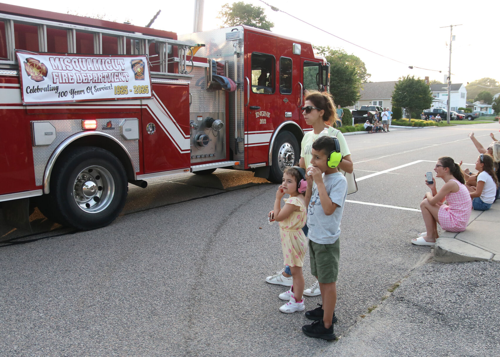 Five year old Li Mila Housseini waves to the passing fire truck as her ...