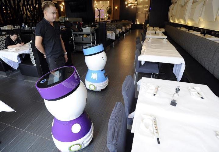 Robots serve customers at the new Robo Sushi in North York