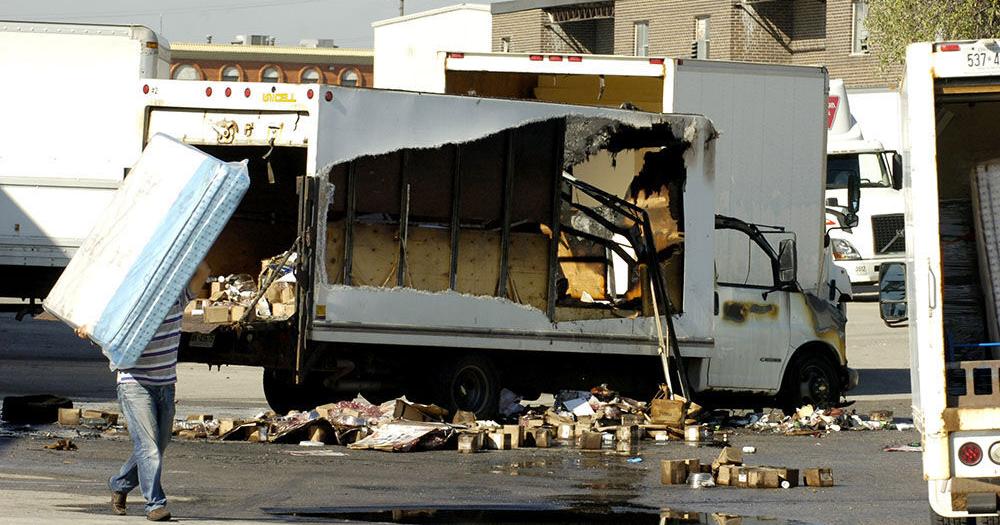 Firefighters drag fire-engulfed cube van away from commercial building