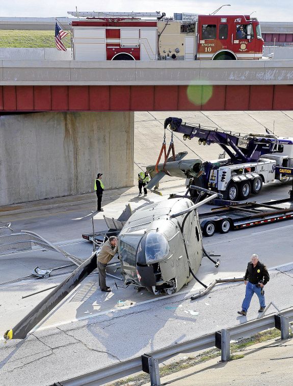 A helicopter being towed to the local airport in preparation for the ...