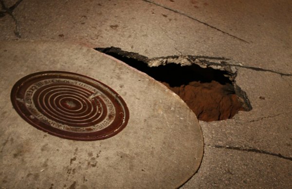Gaping hole opens under street