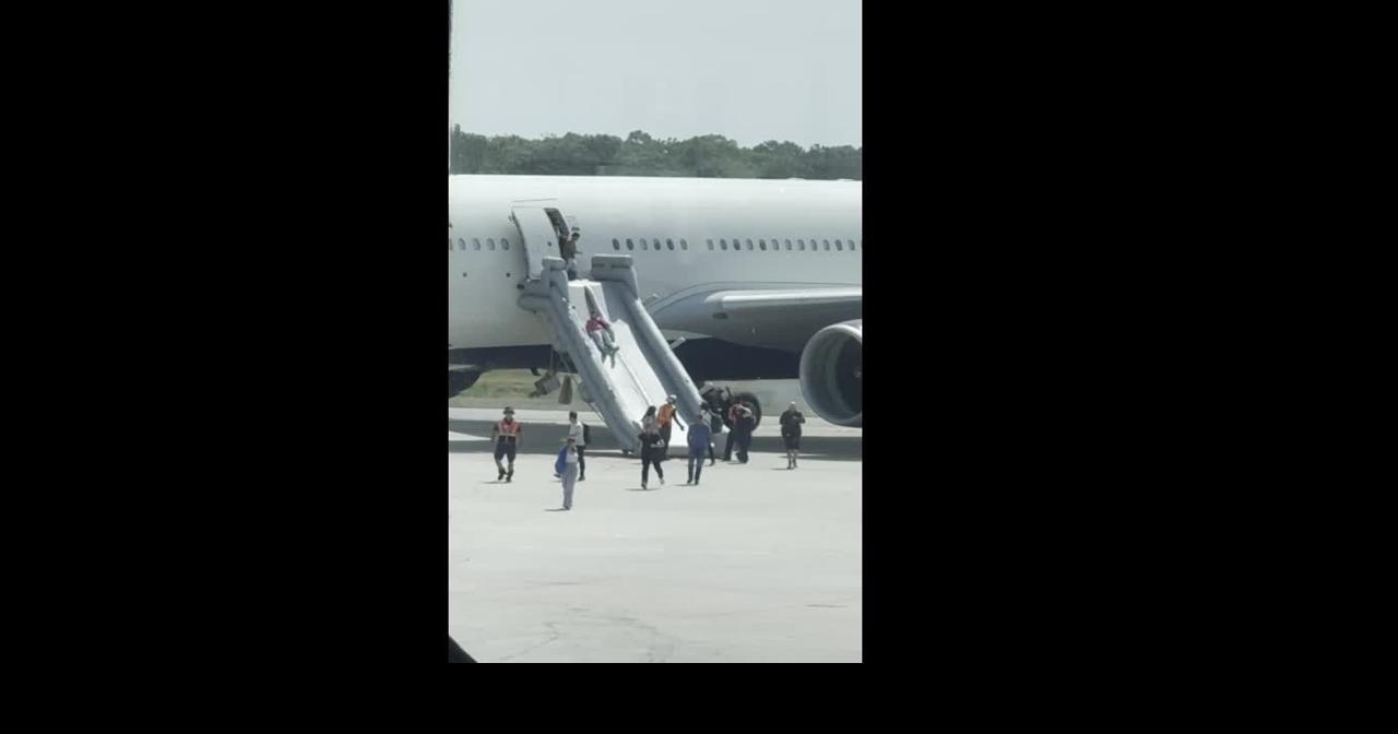 RAW: Delta passengers slide down emergency exit ramp after plane ...