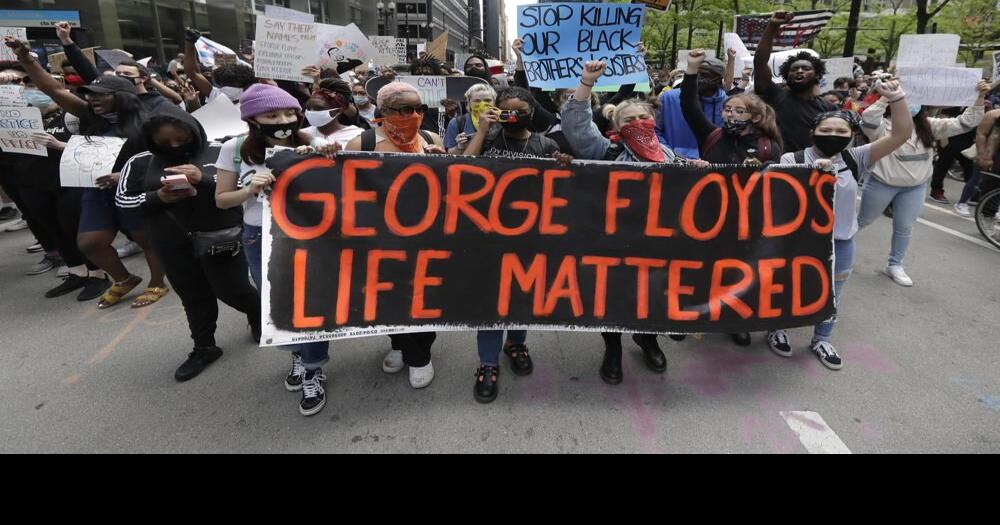 Protesters hold signs as they march during a protest.jpeg | | wdrb.com