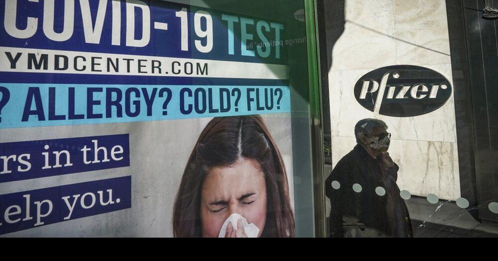 A bus stop ad for COVID-19 testing is shown outside Pfizer world ...