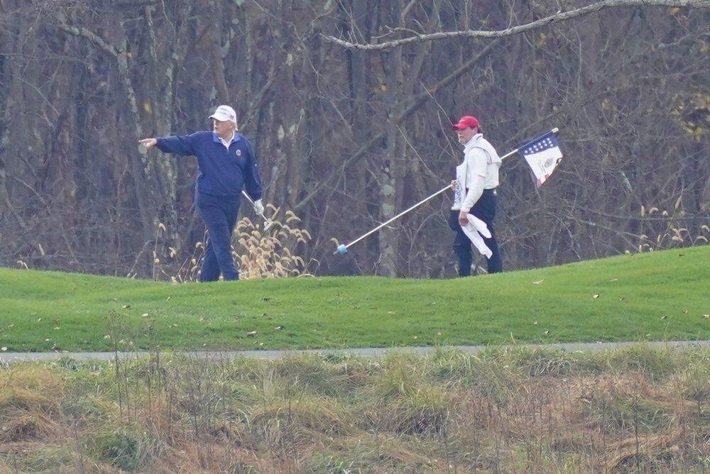 President Donald Trump, left, gesturing while playing golf at Trump ...