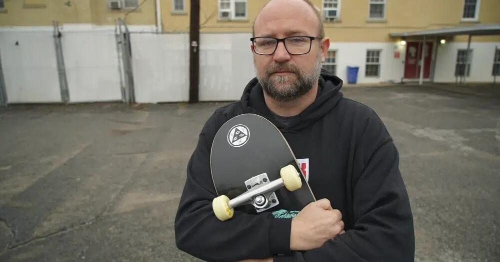 Hunter Demster, an activist, hugs a skateboard.jpg | | wdrb.com