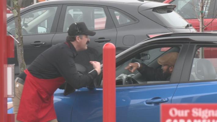 WDRB's Keith Kaiser helps people in line at Scooter's Coffee get ready ...