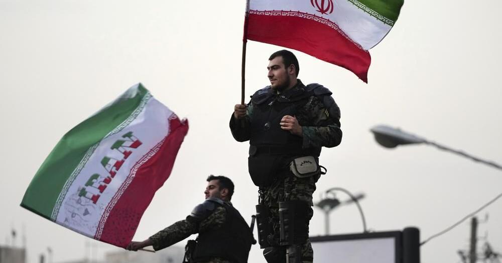 Two anti-riot police officers wave Iranian flags during street ...