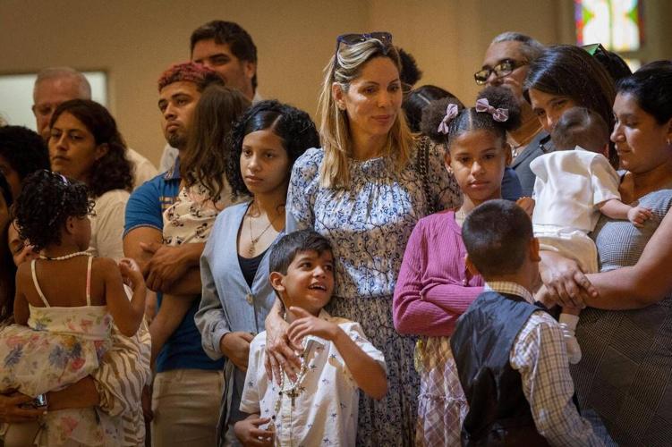 ‘They have been suffering so much.’ Migrant families lean on faith in Catholic baptism ceremony ...