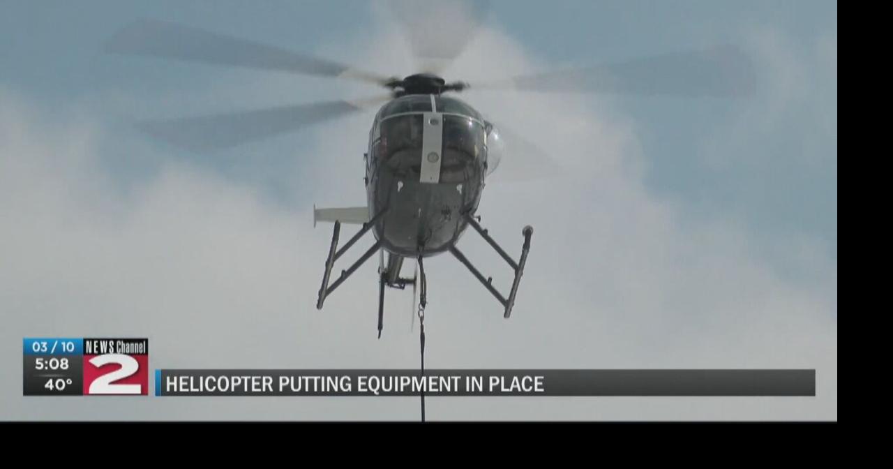 Helicopter comes in to help place equipment along transmission lines ...