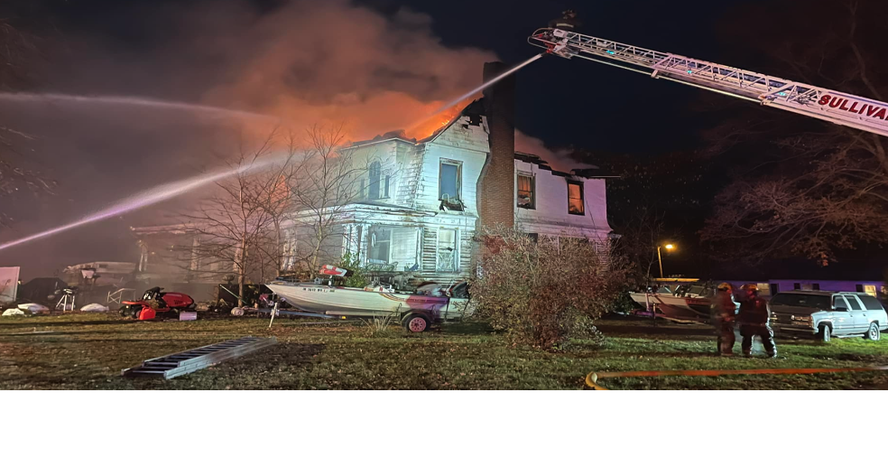 Sullivan fire crews use a ladder truck to save a person trapped on the ...