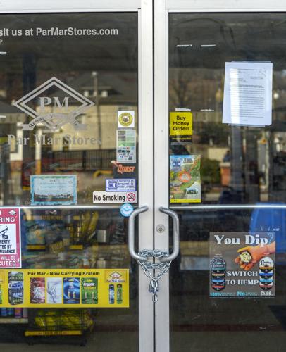 Employees working near temporarily shuttered convenience store express ...