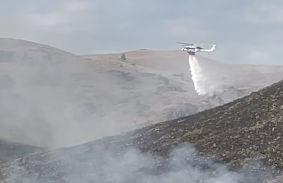 Crews battle 100-acre, human-caused fire on ground and from air near ...
